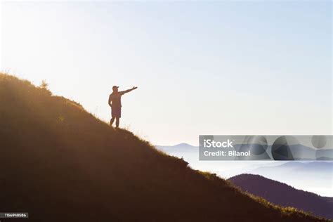 산꼭대기에 있는 남자 감정적 인 장면 배낭을 들고 산 꼭대기에 손을 들고 산의 경치를 즐기는 청년 산 꼭대기에 있는 등산객 스포츠와 활동적인 생활 개념 관광객에 대한 스톡