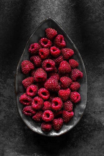 Premium Photo Raspberry Closeup On Dark Grey Plate On Dark Background With Deep Shadows Shot