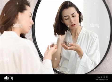 Sad Woman Holding Clump Of Lost Hair Near Mirror Indoors Alopecia