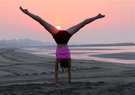 Sun Between The Legs Of The Athletic Gymnast Doing Exercises On The