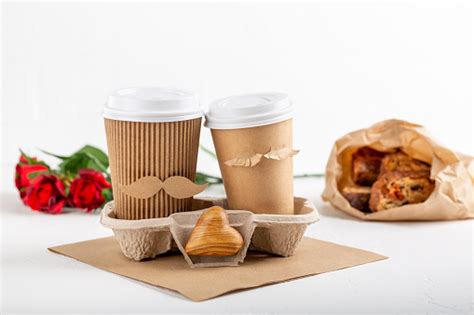 흰색 배경에 골판지 트레이에 커피 두 종이 컵 음식을 꺼내 남자와 여자의 얼굴 사랑의 커플 관계 사랑 개념컵 해피 발렌타인 데이 공간을 복사합니다 밸런타인데이에 대한 스톡