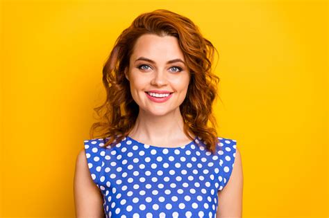 그녀의 클로즈업 초상화 그녀의 좋은 매력적인 사랑스러운 사랑스러운 승리 콘텐츠 쾌활한 쾌활한 물결 모양의 머리 소녀 는 밝은 선명한 빛 선명한 노란색 색상 배경 위에 고립