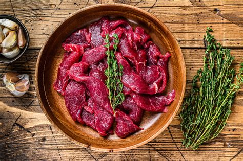 쇠고기 스트로가노프를 위한 신선한 허브와 함께 스트립에 얇게 썬 생 조리되지 않은 쇠고기 고기 나무 배경 위쪽 보기 검은색에 대한 스톡 사진 및 기타 이미지 Istock