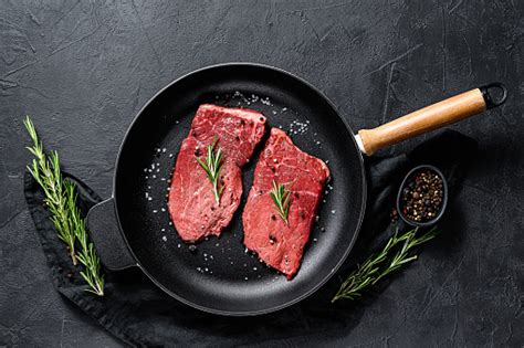 프라이팬에 원시 스트립 허리 스테이크 쇠고기 고기 검은 색 배경입니다 맨 위 보기 Steakhouse에 대한 스톡 사진 및 기타 이미지 Steakhouse 고기