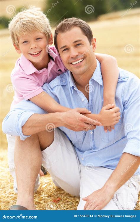 Padre E Hijo Que Se Sientan En Las Balas De La Paja En Cosechado Foto De Archivo Imagen De