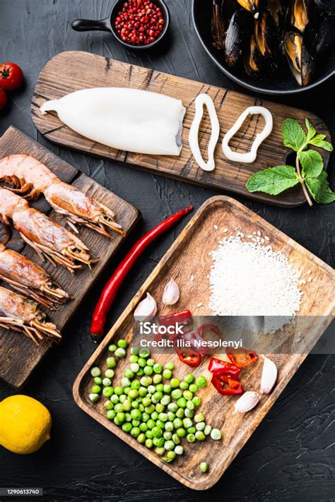 검은 질감의 배경에 왕 새우 홍합 오징어와 신선한 요리되지 않은 빠에야 재료 상단 보기 검정색 배경에 대한 스톡 사진 및 기타