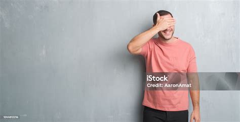 놀람에 대 한 눈을 덮고 얼굴에 손으로 웃 고 웃 고 회색 그런 지 벽에 젊은 백인 남자 눈 먼 개념입니다 가리기에 대한 스톡 사진 및 기타 이미지 Istock