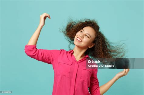 스튜디오에서 파란색 청록색 벽 배경에 고립 된 머리를 끼고 점프 캐주얼에 웃는 아프리카 소녀의 초상화 사람들은 진심으로 감정 라이프 스타일 개념입니다 복사 공간을 모의