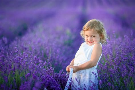 하얀 드레스와 라벤더 부케와 웃는 얼굴로 귀여운 얼굴과 좋은 머리와 모자에 라벤더 필드에 서 있는 곱슬 여자 귀여운에 대한 스톡 사진 및 기타 이미지 Istock