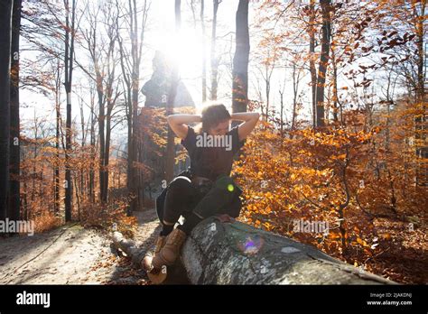 Tourist Girl Sitting On A Log In The Autumn Forest Carpathians