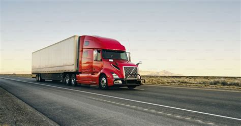 아침 하늘 아래 미국 서부의 탁 트인 고속도로에서 화물을 운반하는 대형 세미 트럭 사진 Unsplash의 사업 이미지