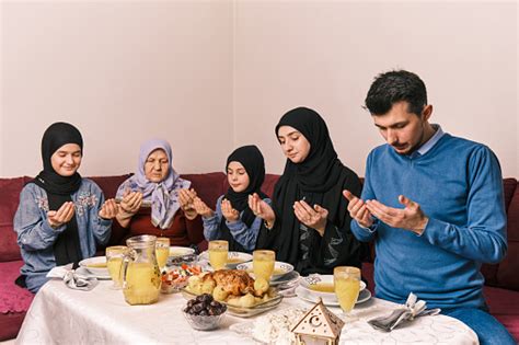 라마단 기간 동안 금식을 깨기 위해 이프타르 두아를 만드는 행복한 무슬림 가족 부모가 자녀와 할머니와 함께 식탁에서 저녁을 먹고 집에서 모여 잔치를 벌입니다 이프타에 대한