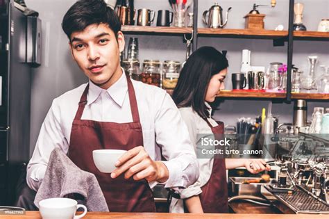 웃 고 뒤에 카페에서 카운터 바 작업 몇 중소 기업 소유자의 초상화 카페에서 커피를 만들기 위한 커피 기계를 사용 하 여 몇
