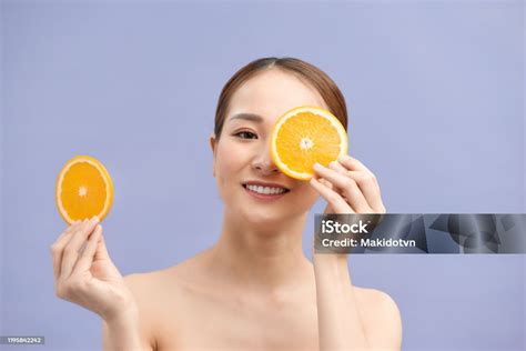 긴 머리 완벽한 피부와 완벽한 메이크업을 가진 아름다운 젊은 아시아 여성 오렌지 잡기 감귤류 과일에 대한 스톡 사진 및 기타