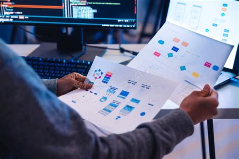 software developer reviews ux ui design diagrams while coding at a