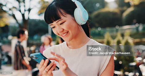 음악 전화 및 일본 여성과 함께 스트리밍 대학 캠퍼스 및 온라인 재생 목록을 위해 공원에서 학생 헤드폰 라디오 및 교육 팟캐스트 일본에서 사람과 모바일과 함께 대학 진학을