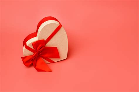 상자 빨간색 리본 하트 모양의 기프트 박스 하나가 왼쪽에 분홍색 배경에 텍스트를 위한 오른쪽 빈 공간에 서 있습니다 발렌타인 데이와 생일 나비매듭에 대한 스톡 사진 및 기타