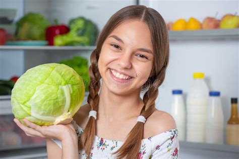 девушка с едой возле холодильника Стоковое Изображение изображение насчитывающей естественно
