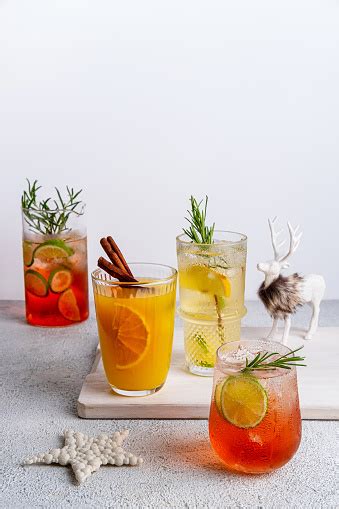 하얀 테이블에 안경을 쓴 세 가지 다채로운 크리스마스 칵테일 신선한 휴일 음료의 구색 딸기 모히토 오렌지 펀치 칵테일 열대 노새 0명에 대한 스톡 사진 및 기타 이미지