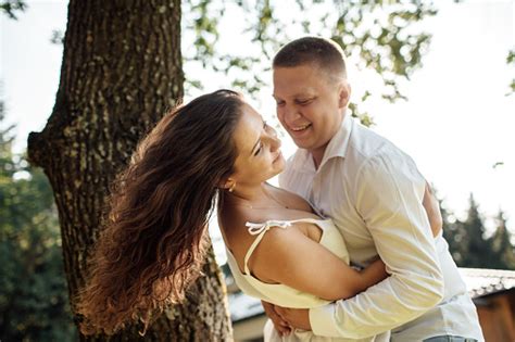여름 화창한 날에 야외에서 즐거운 시간을 보내는 젊은 부부 남자와 여자는 공원에서 나무 근처 포옹 발렌타인 20 29세에 대한