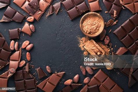 초콜릿 코코아 파우더 강판 및 콩 코코아 바 및 검은 색 배경에 다른 우유와 다크 초콜릿 조각의 구성 베이킹 초콜릿 텍스처 복사 공간이 있는 위쪽 보기입니다 모의 0명에