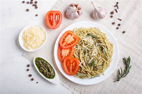 페스토 소스를 곁들인 스파게티 파스타 토마토 치즈를 흰색 나무 배경의 린넨 식탁보에 얹어 놓습니다 상단보기 평평한 평신도 0명에 대한 스톡 사진 및 기타 이미지 Istock