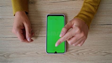 Hands Scrolling Green Screen Cellphone Browsing App At Desk Closeup Top View Stock Footage
