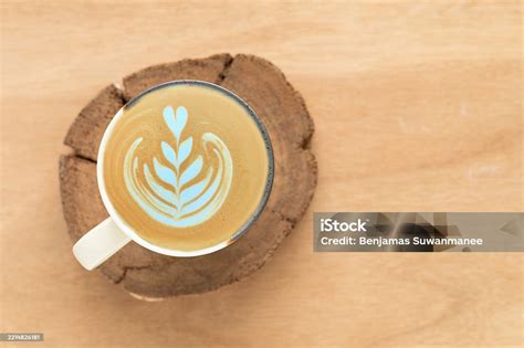 평면도 카푸치노는 하트 형태의 라떼 아트를 특징으로 하며 소박한 나무 위에 흰색과 갈색의 얼룩덜룩한 세라믹 머그잔에 흰색 거품으로 만들어졌습니다 0명에 대한 스톡 사진 및