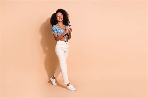 사랑 스럽다 사랑스러운 소녀 입고 푸른 정상 걷기 문자 메시지 현대 장치 빈 공간 고립 된 베이지 색 배경을 입고 사진 25 29세에 대한 스톡 사진 및 기타 이미지