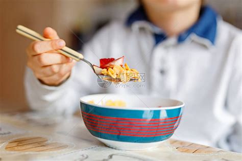 小学生男孩吃麦片加牛奶和浆果高清图片下载 正版图片507364784 摄图网