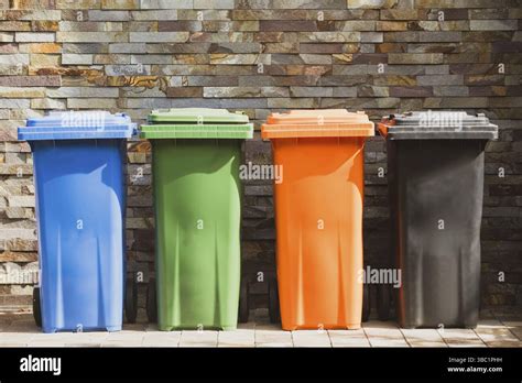 Four Plastic Trash Containers Of Different Colours For Garbage