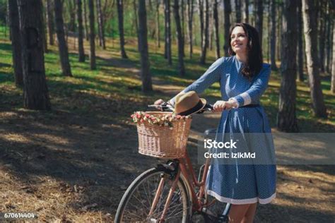 아름 다운 젊은 웃는 여자 짧은 검은 머리와 모자 서 근처 Chamomiles의 거 대 한 꽃다발 바구니 자전거 여름 소녀 즐기는 야외 자연입니다 녹색 배경입니다 갈색