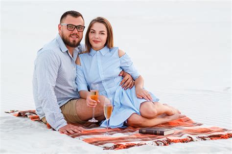 모래 해변 담요 해변에서 피크닉을 즐기는 행복 한 커플에 앉아 행복 한 부부와 여름 휴가에 좋은 시간을가지고 멋진 매력적인 커플은 화이트에 함께 앉아 2명에 대한 스톡 사진