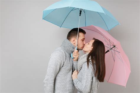 회색 벽 배경 스튜디오 초상화에 고립 된 우산 아래 함께 회색 스웨터 스카프에 커플 여자 사람입니다 건강 한 생활 습관 병 아픈 질병 치료 추운 계절 개념 복사 공간을 모의