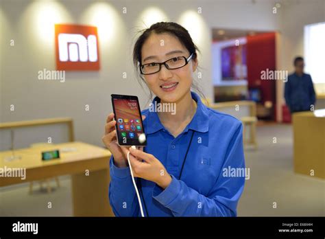 A Girl Staff Shows A Xiaomi Redmi Note In Xiaomi Experience Center In Beijing China Mar