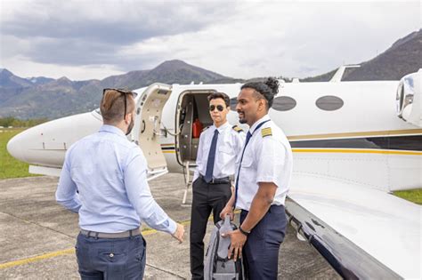 Corporate Businessman Meet The Pilots Near Private Jet Plane Stock