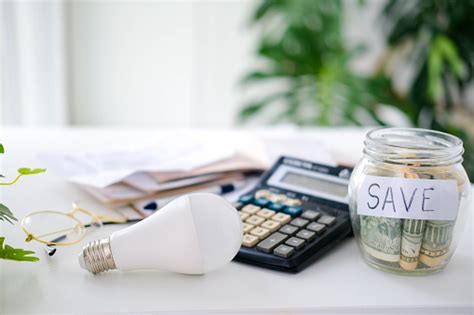 에너지 절약 및 비용 개념 Led 램프 계산기 및 달러 돈으로 돼지 저금통 비문이있는 유리 병에 돈을 저장하십시오 Led 조명에 대한 스톡 사진 및 기타 이미지 Istock