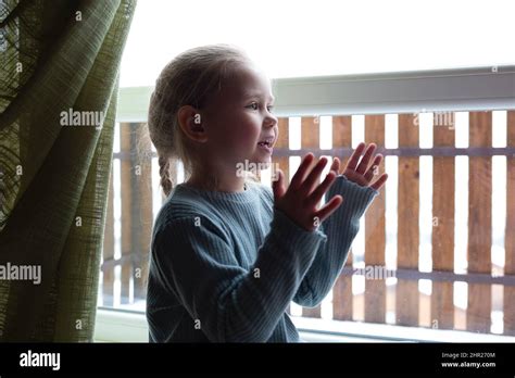 Little Cute Girl Clapping Her Hands Sitting By The Big Window Stock