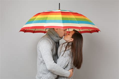 회색 벽 배경 스튜디오 초상화에 고립 된 우산 아래 함께 회색 스웨터 스카프에 커플 여자 사람입니다 건강 한 생활 습관 병 아픈