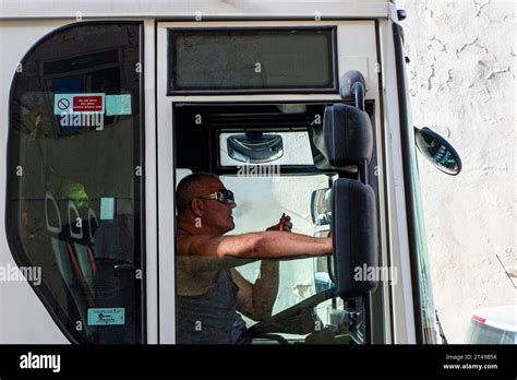 The Driver Of A Refuse Truck Collecting Rubbish Enjoys A Vape Stock