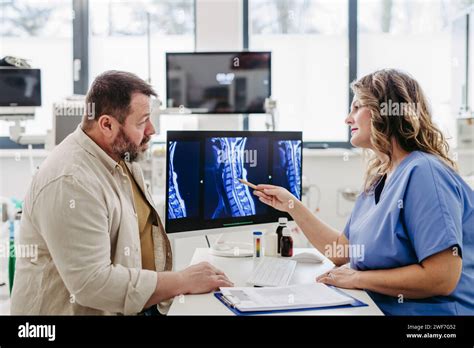 Doctor Consulting With Overweight Patient Discussing Test Result And X