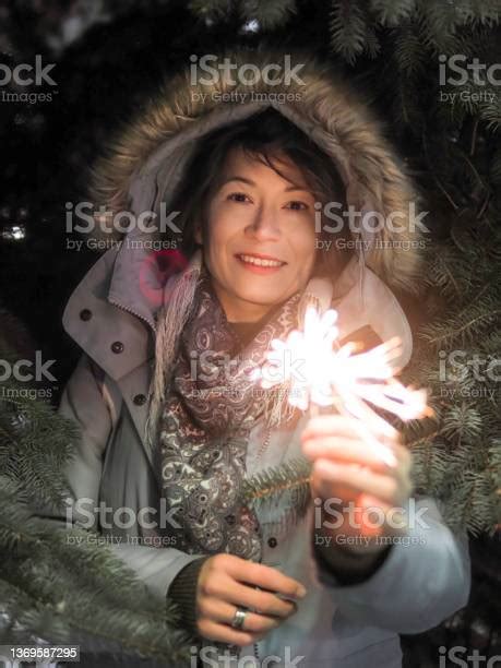 웃는 여자는 밝은 스파클러와 크리스마스 또는 새해를 축하합니다 벵골 화재 겨울 휴가 축하 야외에 대한 전통적인 불꽃 놀이 12월