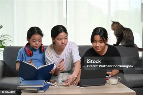 디지털 태블릿에서 온라인으로 만화를 보고 소파에 앉아 있는 세 명의 어린이 10 11세에 대한 스톡 사진 및 기타 이미지 10 11세 3 명 8 9 살 Istock