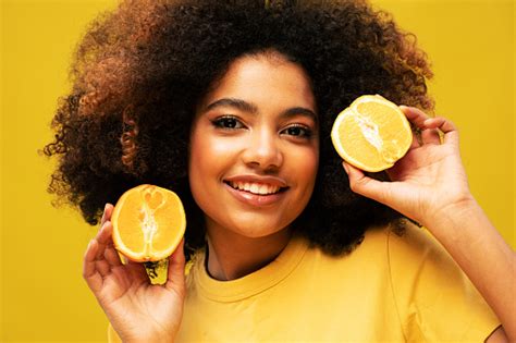 건강한 여름 다이어트 및 사람들 개념 귀 근처에 오렌지를 들고있는 쾌활한 아프리카 여성 14 15 살에 대한 스톡 사진 및 기타