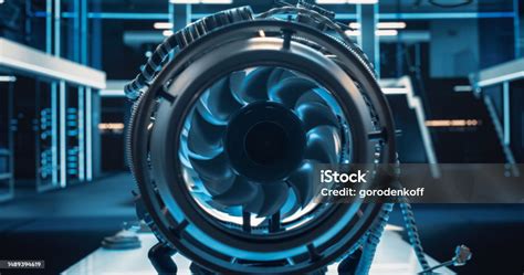 회전하는 팬이 있는 고급 미래형 터빈 엔진의 연소실 내부에서 찍은 사진을 닫습니다 연구 개발 시설에 있는 현대 산업 제트기 엔진