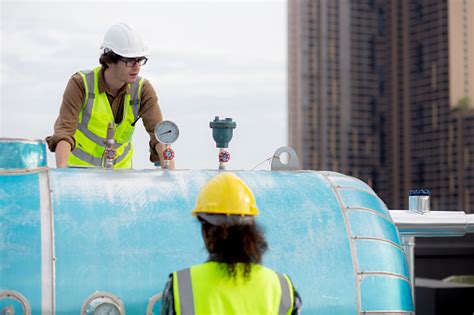 젊은 여성과 남성 엔지니어가 파이프 라인을 검사하고 공장 정비사 또는 기술자 검사관에서 이야기하고 배관공 밸브와 토론을 함께