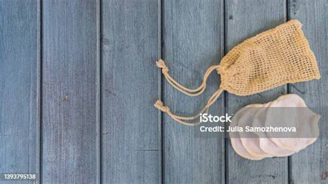 천연 코튼 재사용 가능한 메이크업 리무버 패드는 파란색 나무 배경에 에코 백으로 제공됩니다 플랫 레이 복사 공간 플라스틱 무료 폐기물 제로 유기농 스킨케어 액세서리 0에