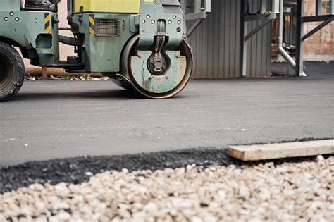 아스팔트 콤팩터는 도로 수리 작업을 수행하고 있습니다 새로운 아스팔트를 누워 대형 중장비 새로운 아스팔트 도로의 건설 거리에