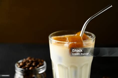 커피로 만든 우유와 얼음 조각이 있는 클로즈업 유리 갈색 배경에 금속 튜브가있는 아이스 커피 커피 마실 것에 대한 스톡 사진 및 기타 이미지 Istock