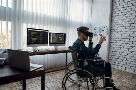 Side View Of Young Male Web Developer In A Wheelchair Wearing Virtual
